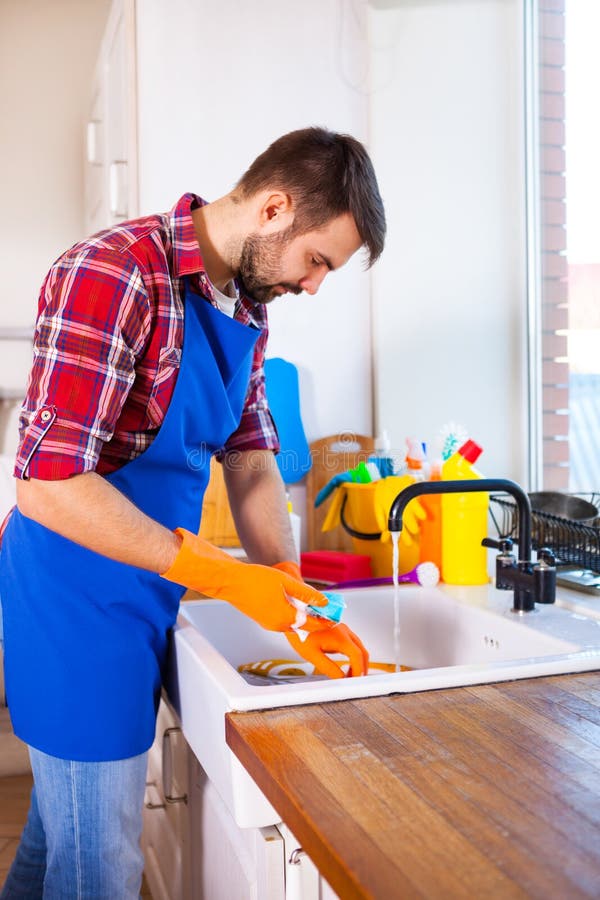 Man Makes Cleaning the Kitchen. Young Man Washes the Dishes. Cleaning ...