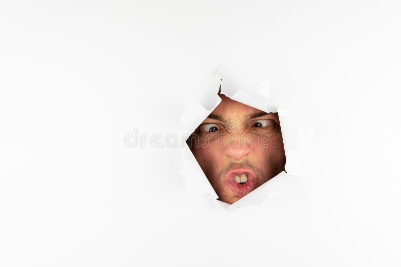 The Man Makes a Face through a Hole in the White Wall Stock Image ...