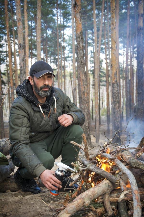 A Man Makes a Fire in the Forest with a Lighter. Close-up of a Man ...
