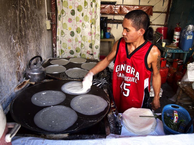 A Man Makes Spring Roll Wrappers Inside His Store at a Market ...