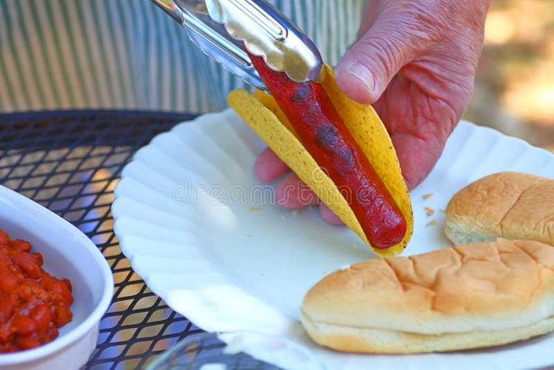 Man Putting Hot Dog in Taco Shell Stock Photo - Image of male, adult ...