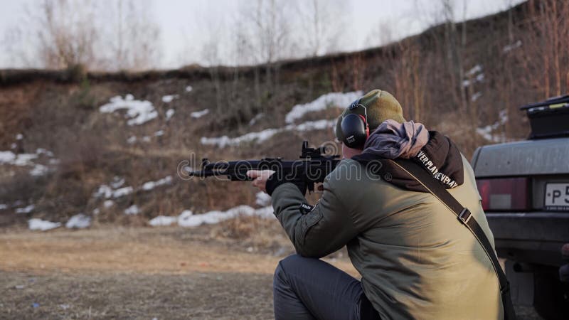 The Man Makes Two Shots from an Assault Rifle from a Sitting Position ...
