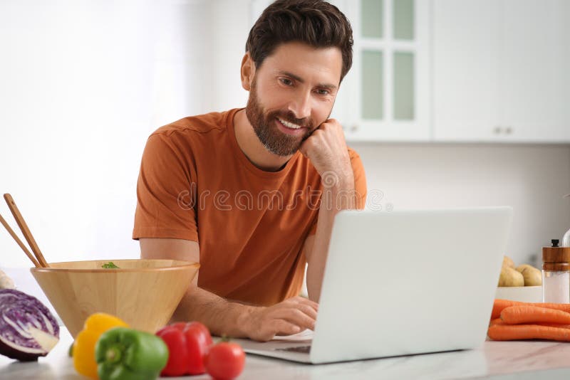 Man Making Dinner while Watching Online Cooking Course Via Laptop in ...