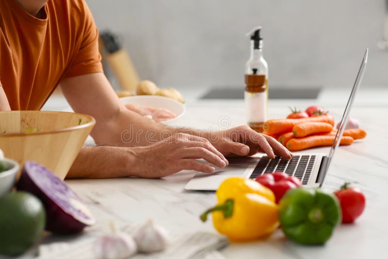 Man Making Dinner while Watching Online Cooking Course Via Laptop in ...
