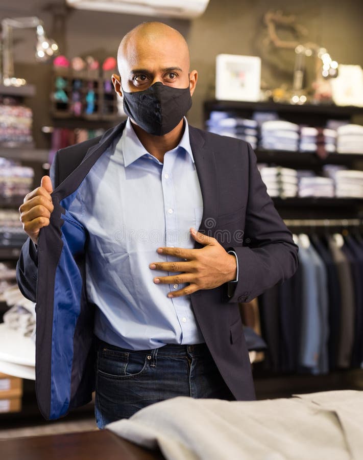 Man in Mask Choosing Jacket in Store Stock Photo - Image of suit ...