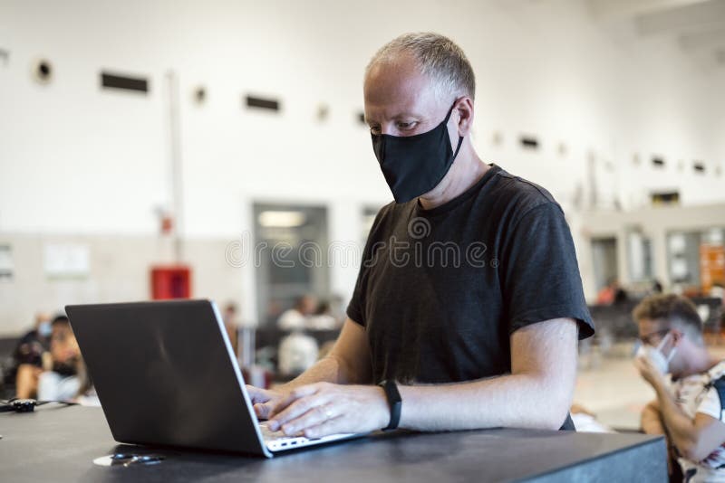 Man in a Mask Working at His Laptop at the Airport Stock Photo - Image ...