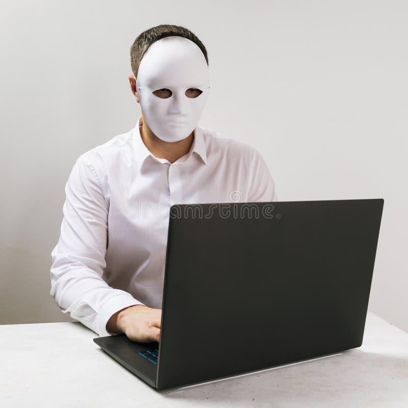 A Man in a Mask Works Behind a Laptop, the Concept of Anonymity on the ...