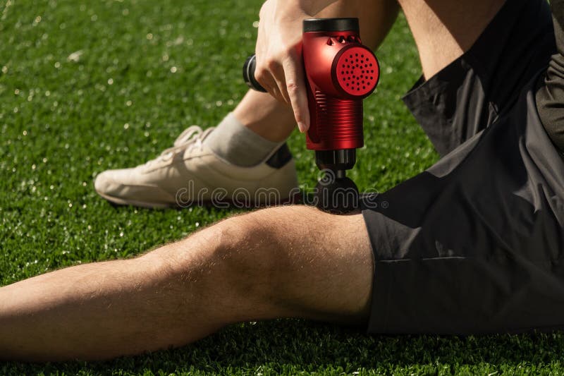 Man Massaging Legs with Massage Percussion Device after Workout. Stock ...
