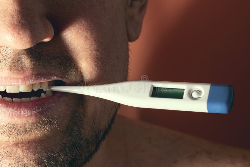 Man Measures Temperature With A Modern Electronic Thermometer Stock