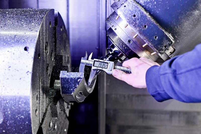 A Man Measures a Workpiece with a Digital Caliper on a CNC Milling ...