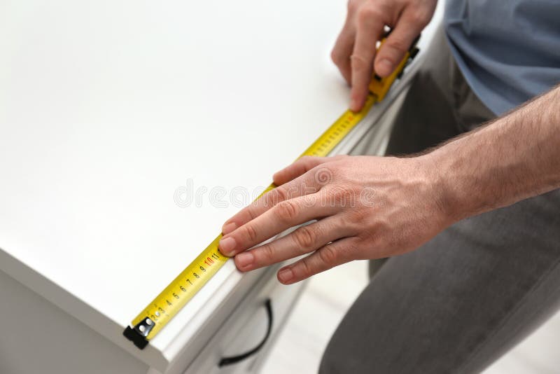 Man Measuring Chest of Drawers Indoors. Construction Tool Stock Image ...
