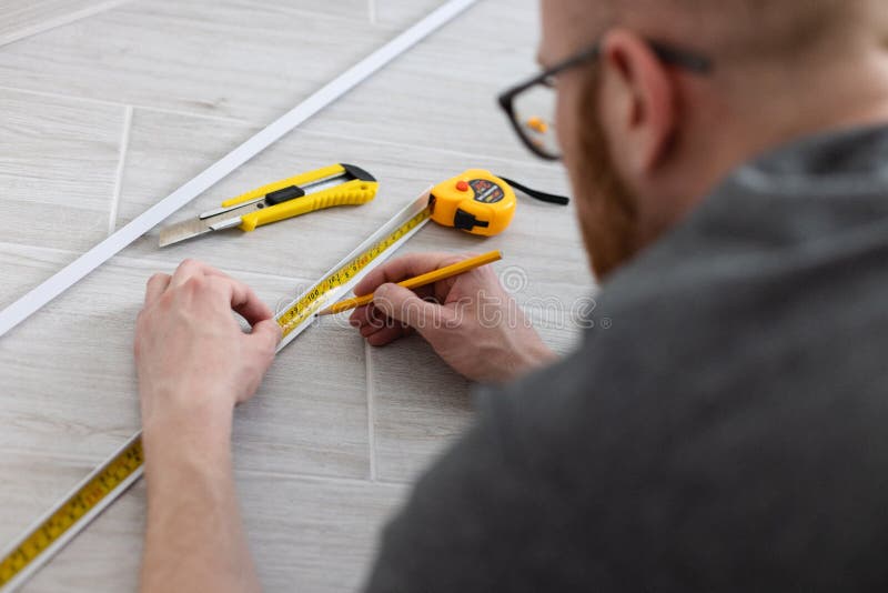 Man Measuring Decorative Plastic Corner. Man with Measuring Tools ...