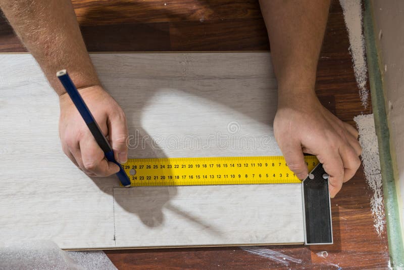 Man measuring floor panels stock image. Image of room - 281187223
