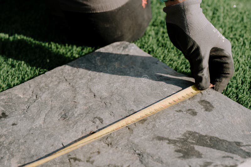 Man Measuring the Length of a Rock on the Ground Stock Photo - Image of ...