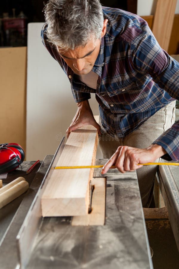 Man measuring a plank stock photo. Image of carpentry - 65261494