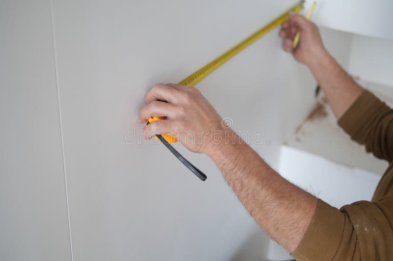 Man Measuring Wall with a Tape Measure Stock Image - Image of ...