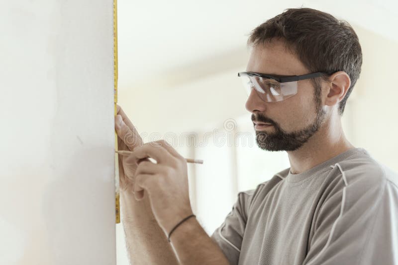 Man Measuring a Wall Using a Folding Ruler Stock Photo - Image of ...