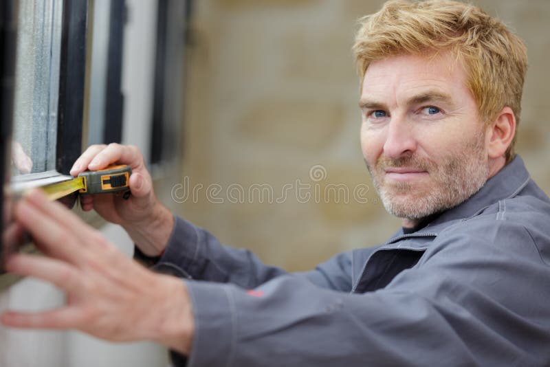 Man Measuring Window Prior To Installation Roller Shutter Outdoors ...