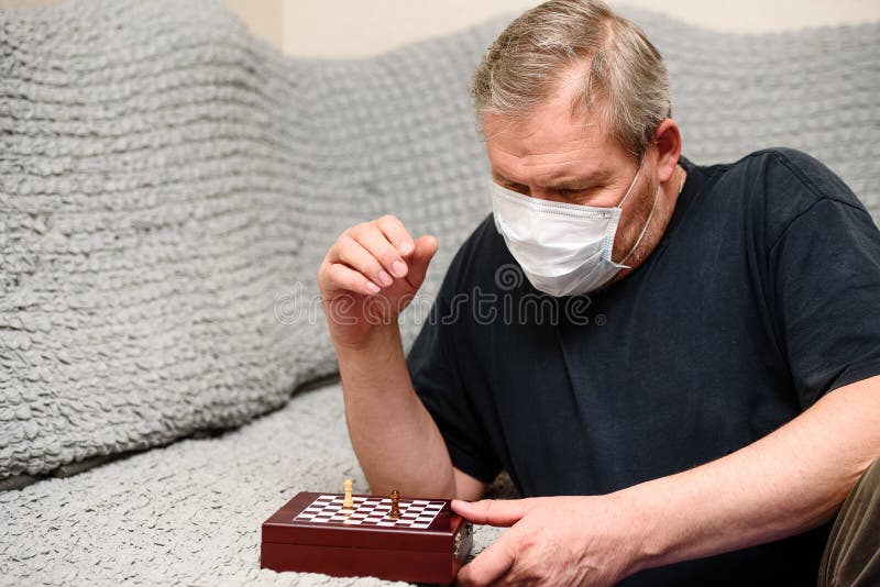 Man in a Medical Mask on Self-isolation-playing Chess Alone Stock Photo ...