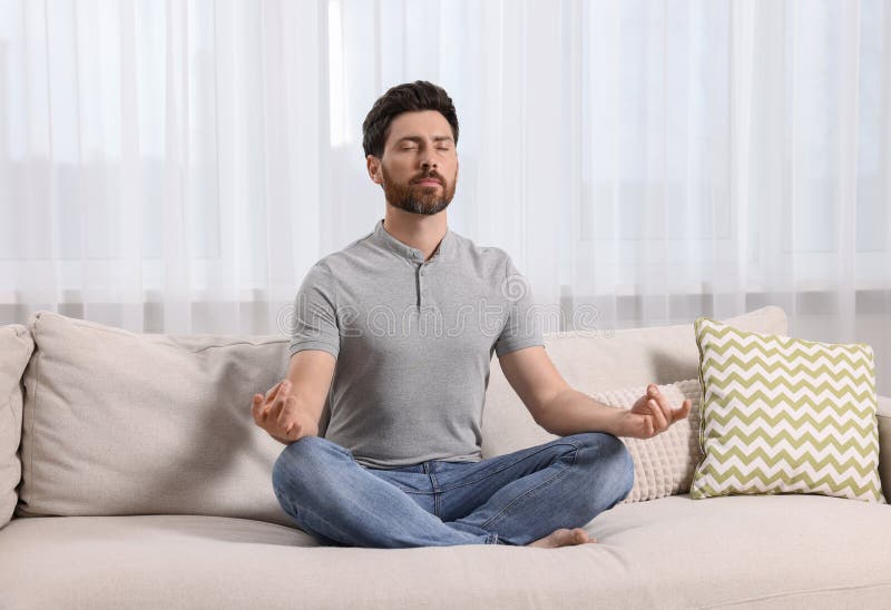 Man Meditating on Sofa at Home. Harmony and Zen Stock Image - Image of ...