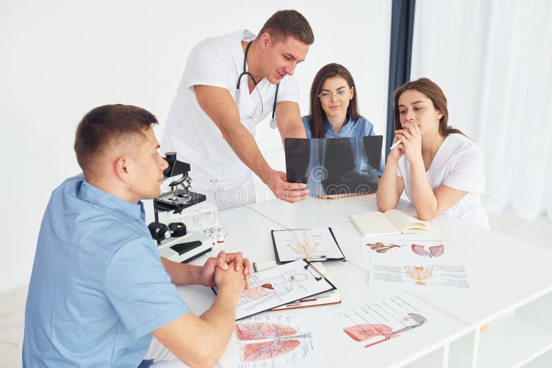 Man with Microscope. Group of Young Doctors is Working Together in the ...