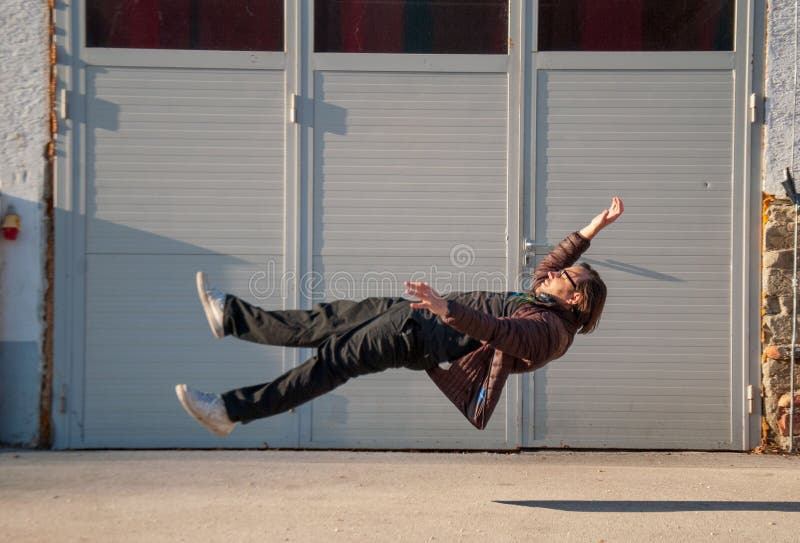 Man in Mid-air with a Gray Gate on the Background Stock Photo - Image ...