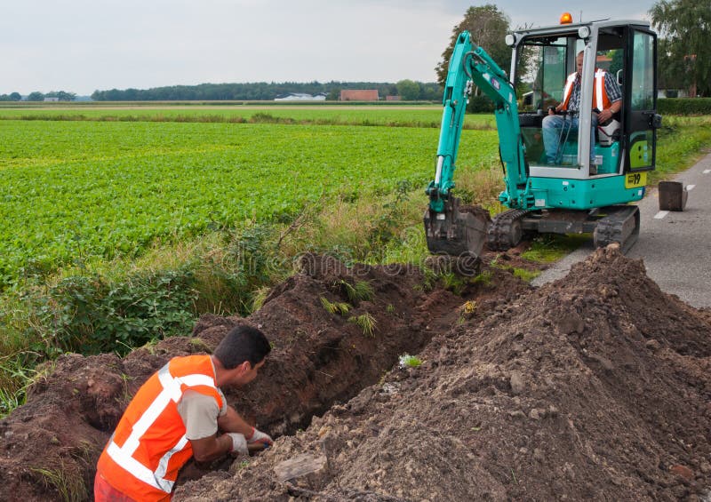 Man and Mini Excavator Dig a Trench To Lay Cables Editorial Stock Photo ...