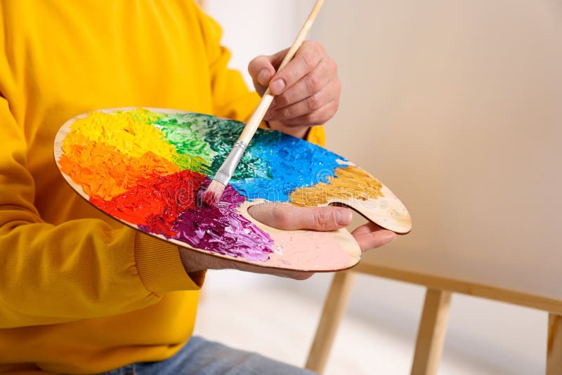 Man Mixing Paints on Palette with Brush in Studio, Closeup. Using Easel ...