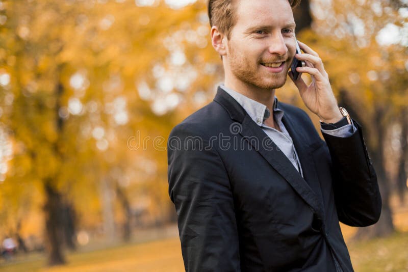 Man with Mobile Phone in the Autumn Park Stock Image - Image of looking ...