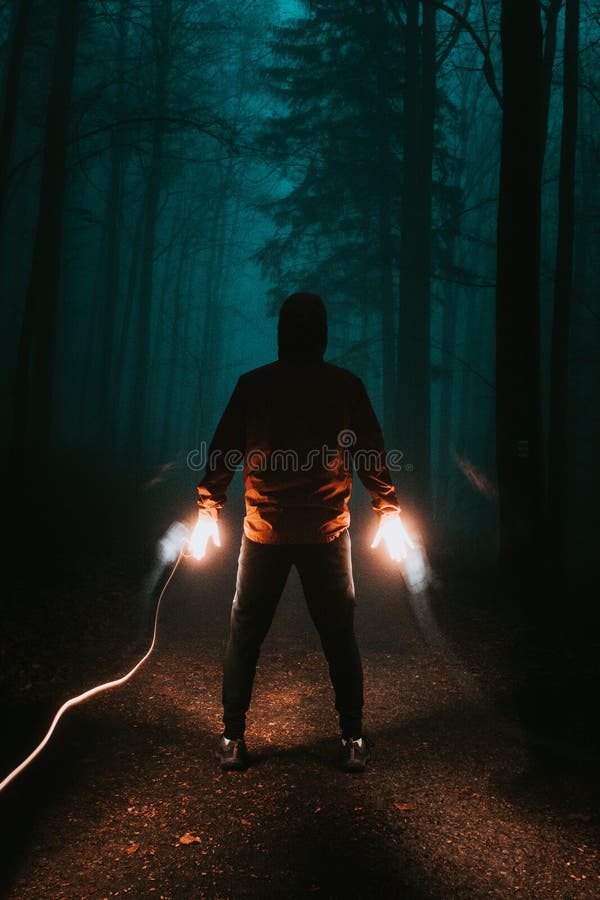Man in Motion Makes a Line of Fire Behind Him with His Hands in a ...