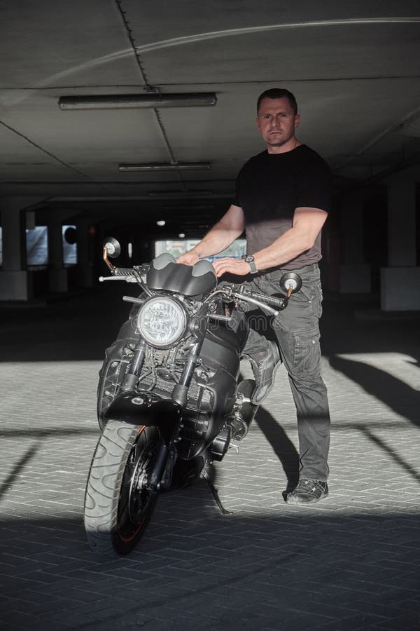 A Man and Motorcycle in Underground Parking Garage Stock Photo - Image ...