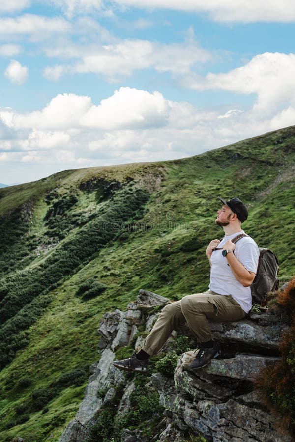 Man in the Mountains Sitting on a Rock Stock Image - Image of greenery ...