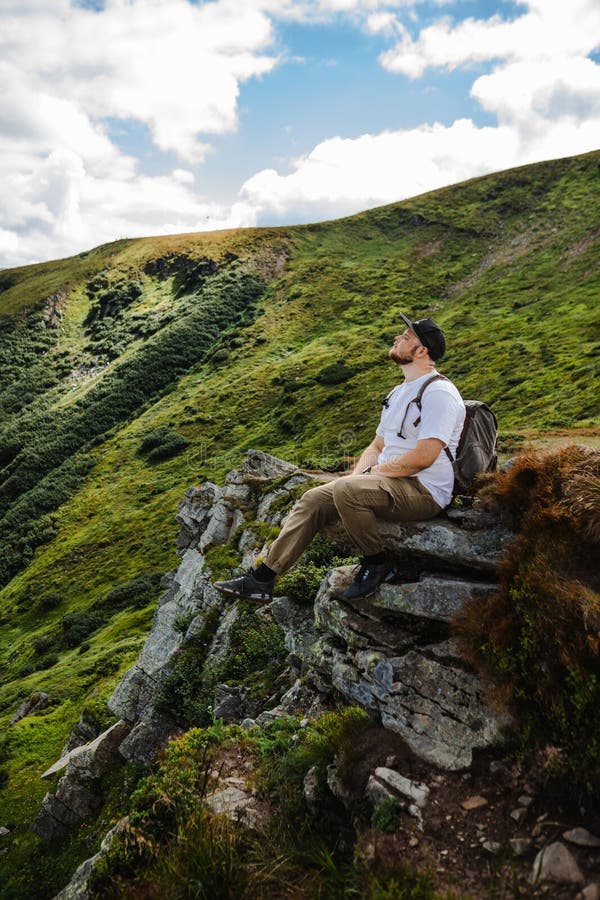 Man in the Mountains Sitting on a Rock Stock Image - Image of ...
