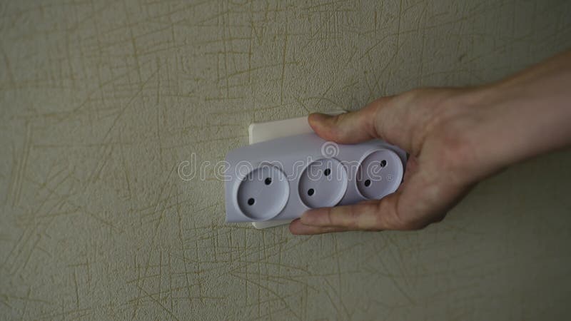 Man Mounting Multiple Socket Outlet on Light Textured Wall at Home ...