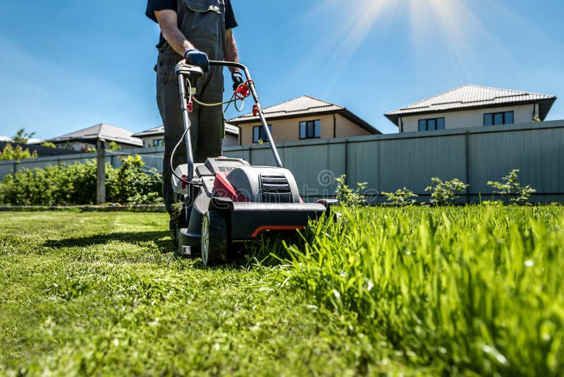 Man Mowing Lawn in the Backyard of His House. Man with Lawn Mower Stock ...