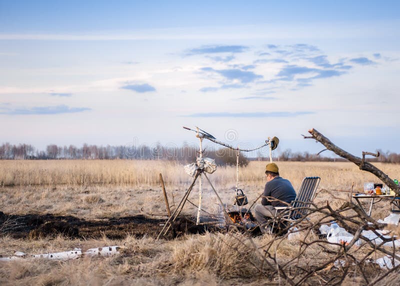 A Man Near a Fire Boils a Kettle and Rests after Hunting Stock Image ...