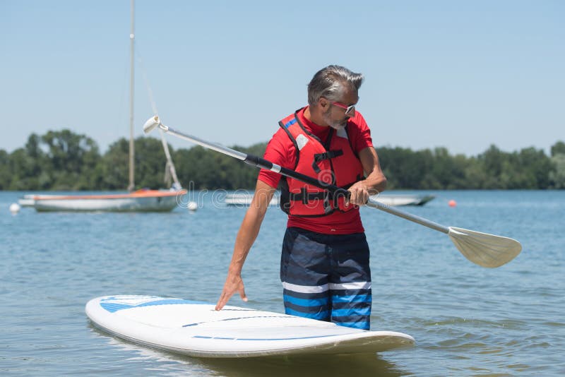 Man Next To Stand-up Paddle Board on Lake Stock Image - Image of ...