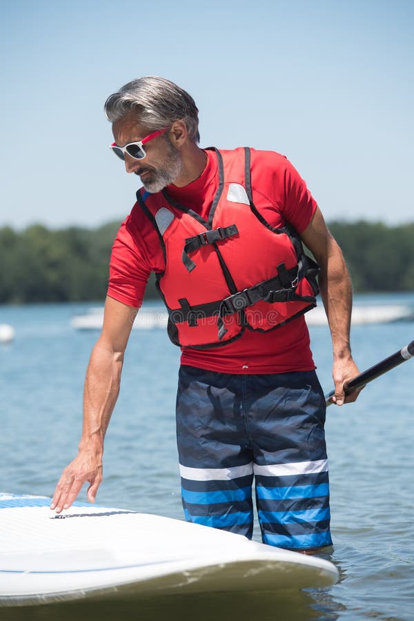 Man Next To Stand-up Paddle Board on Lake Stock Image - Image of ...