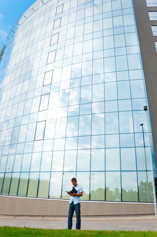 Man with Notebook and Mobile Phone in Front of Modern Business Building ...