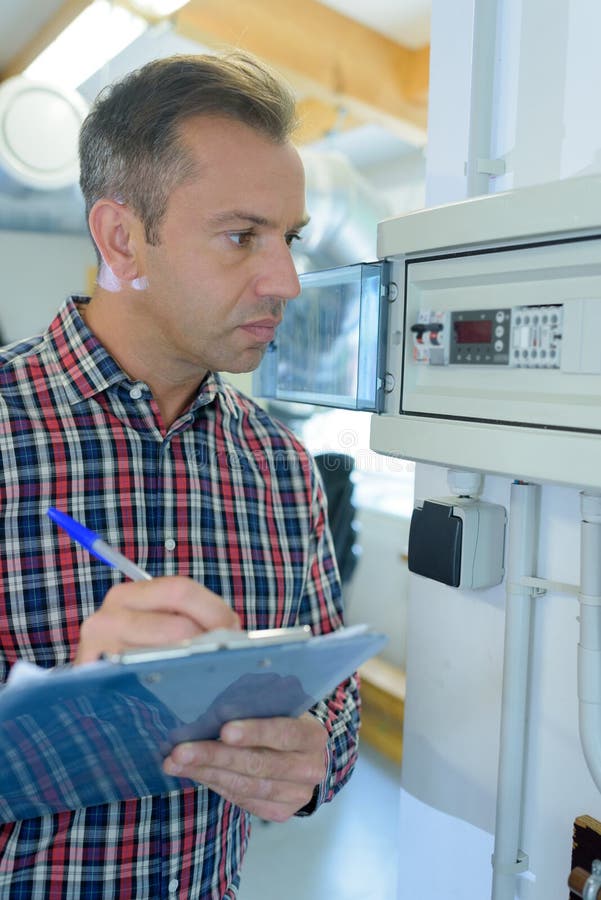 Man Noting Reading from Electricity Meter Onto Clipboard Stock Photo ...