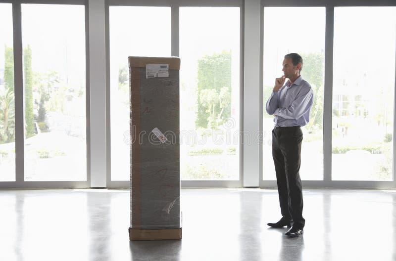 Man Observing Package in Empty Office Stock Photo - Image of loneliness ...