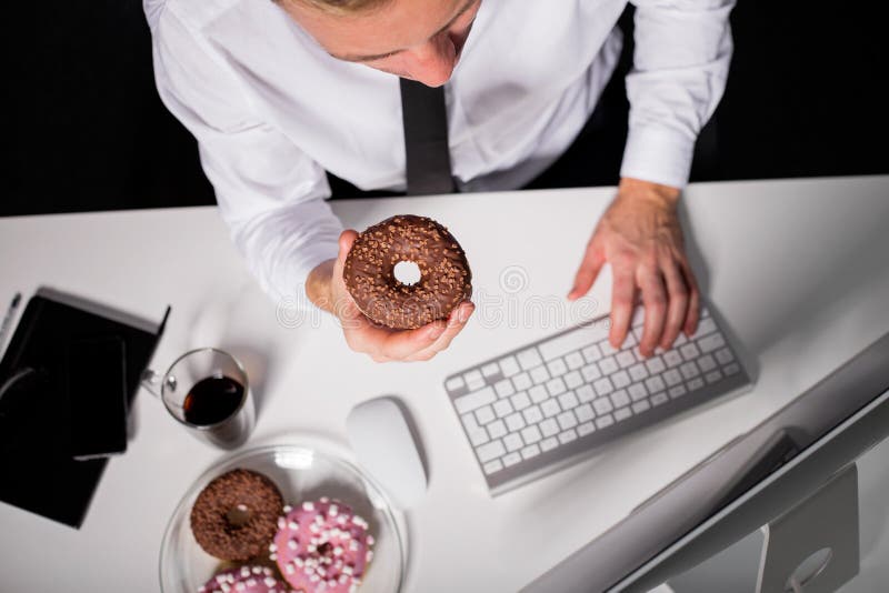 Man at the Office Eating Donuts Stock Image - Image of gadgets, tasty ...