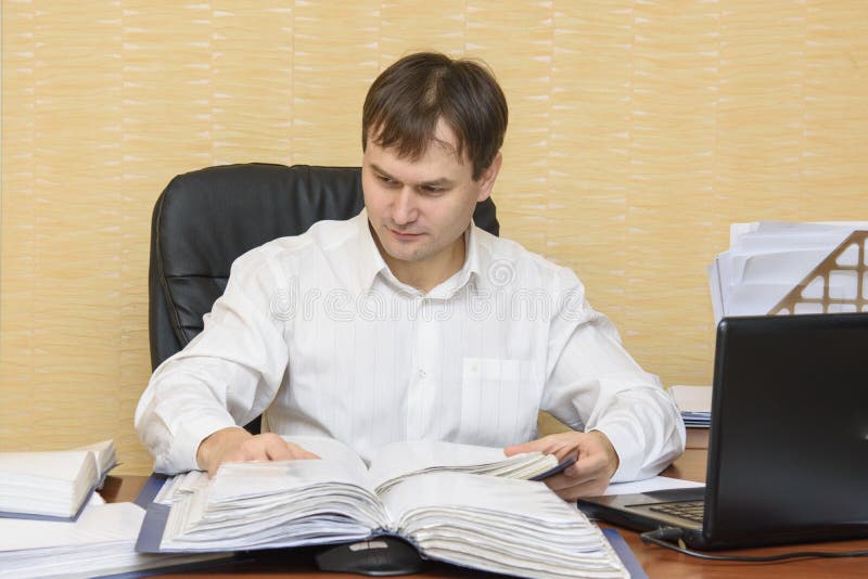The Man in the Office Looking at Documents in Folders Stock Photo ...