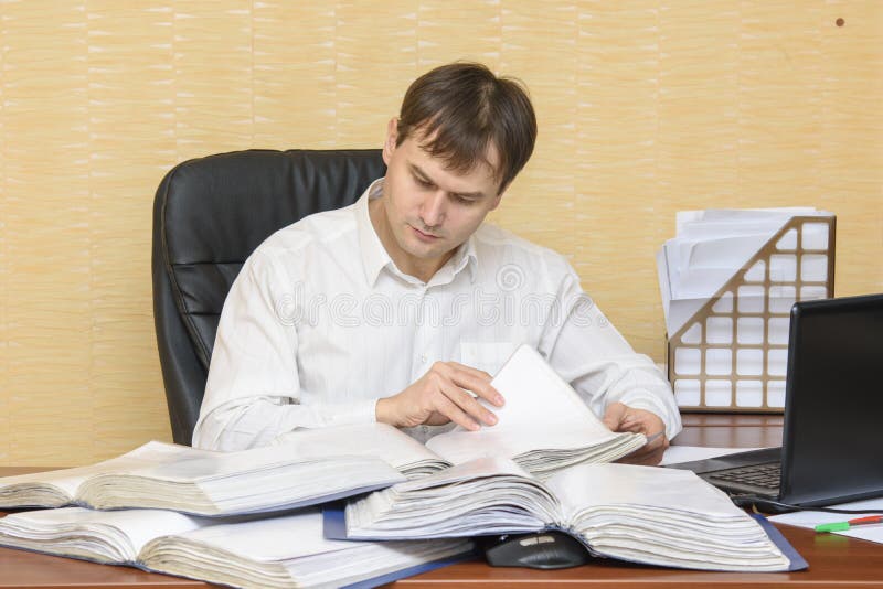 The Man in the Office Looking at Documents in Folders Stock Photo ...