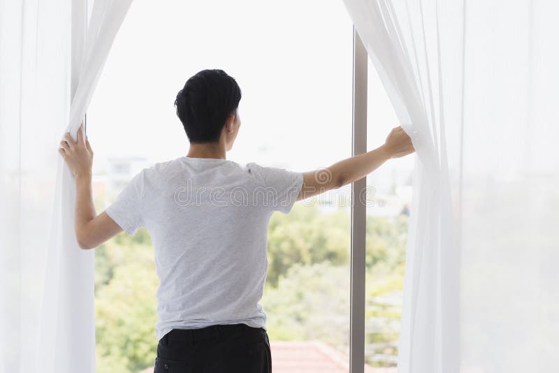 Man Open the Curtain and Look Outside the Window Stock Photo - Image of ...
