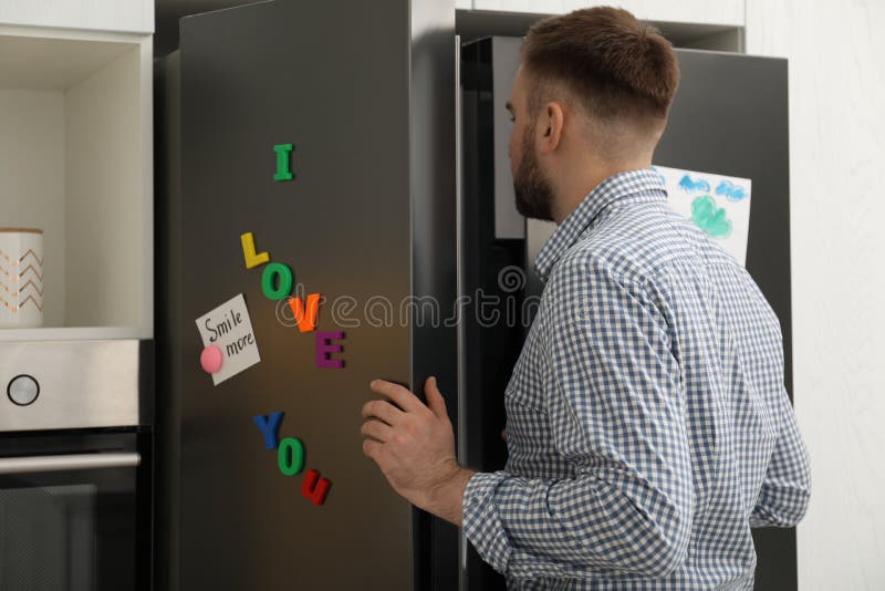 Man Opening Refrigerator Door with Notes and Magnets Stock Photo ...