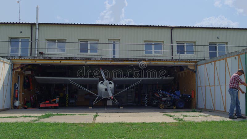 Man Opening Shutter Hangar with Airplane Preparing Private Plane To ...