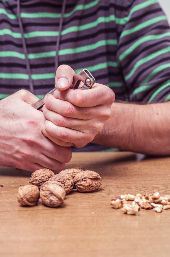 Man Opening Some Walnuts on a Table Stock Image - Image of walnut, food ...