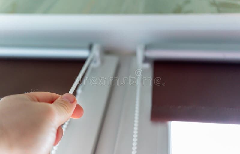 Man Opens / Closes the Roller Blinds Installed on the Window Stock ...