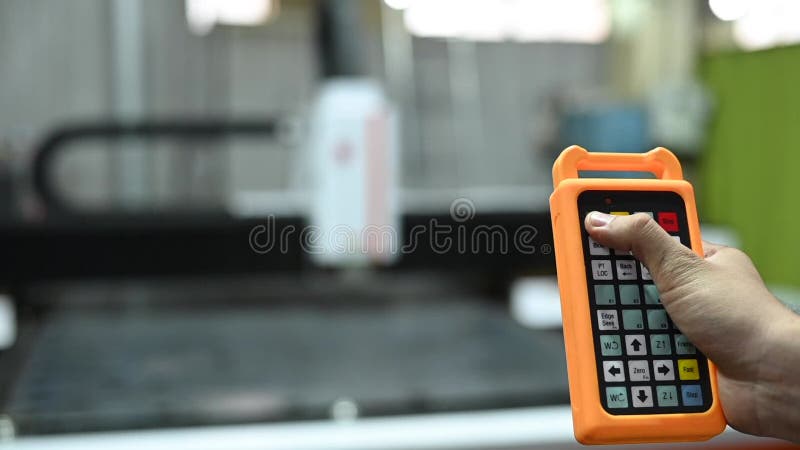 A Man Operates a CNC Machine Using a Remote Control. Laser Cutting of ...